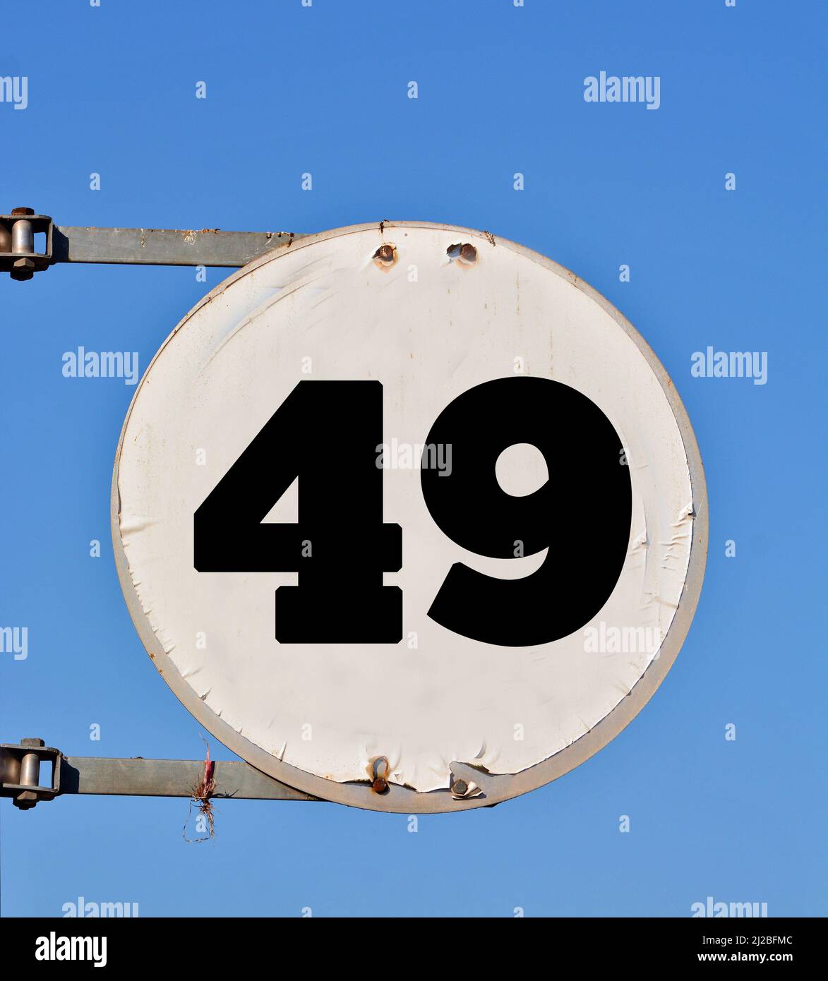 A speed limit sign with number 49 added on it against a blue sky Stock ...