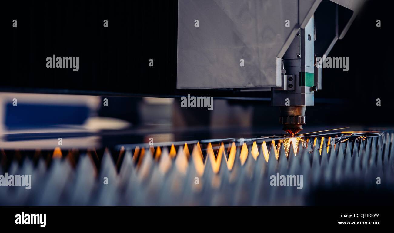 Blue color Laser CNC cut of metal with light spark, technology modern ...