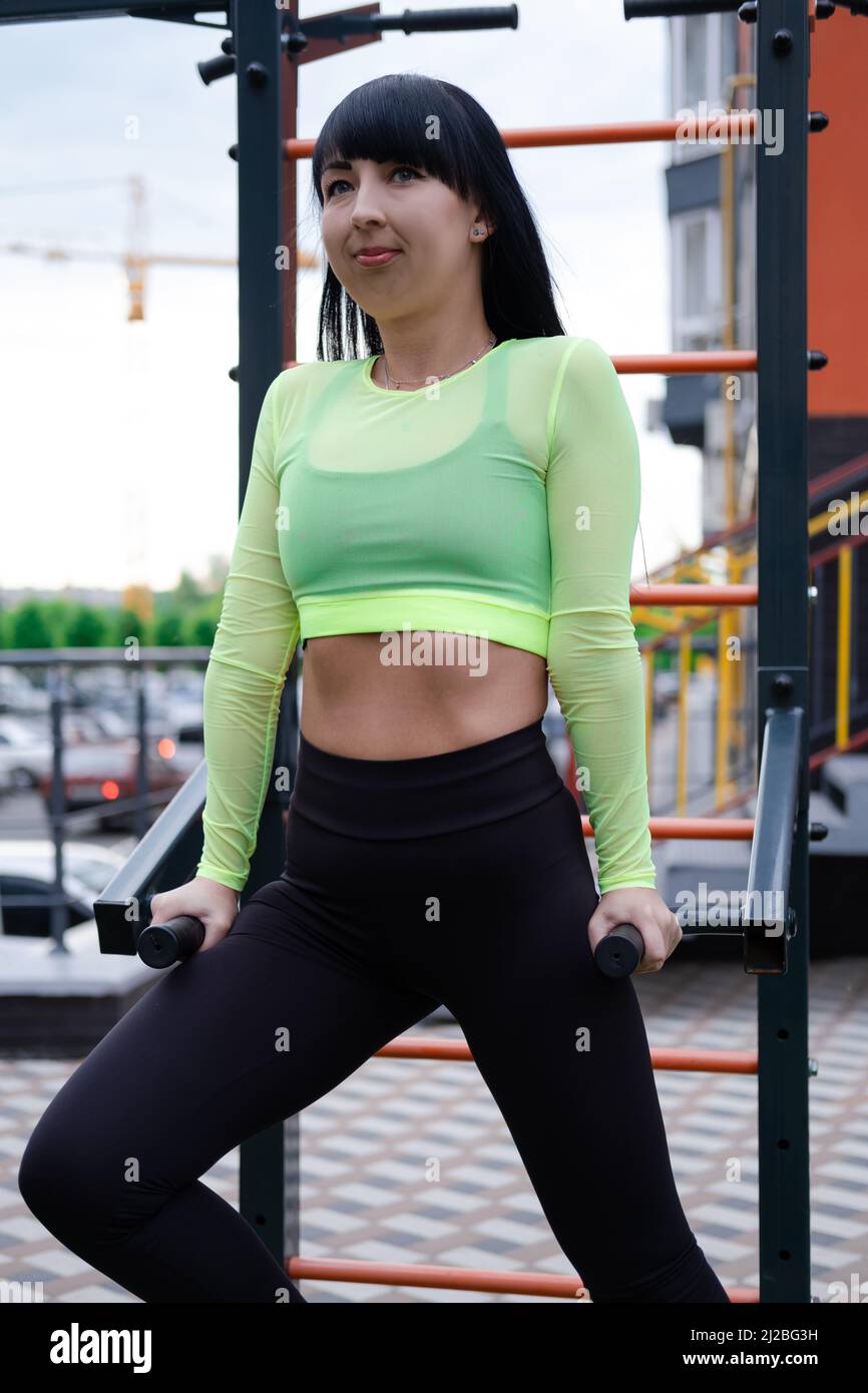 sporty woman in black and green sportswear doing sport exercises ...