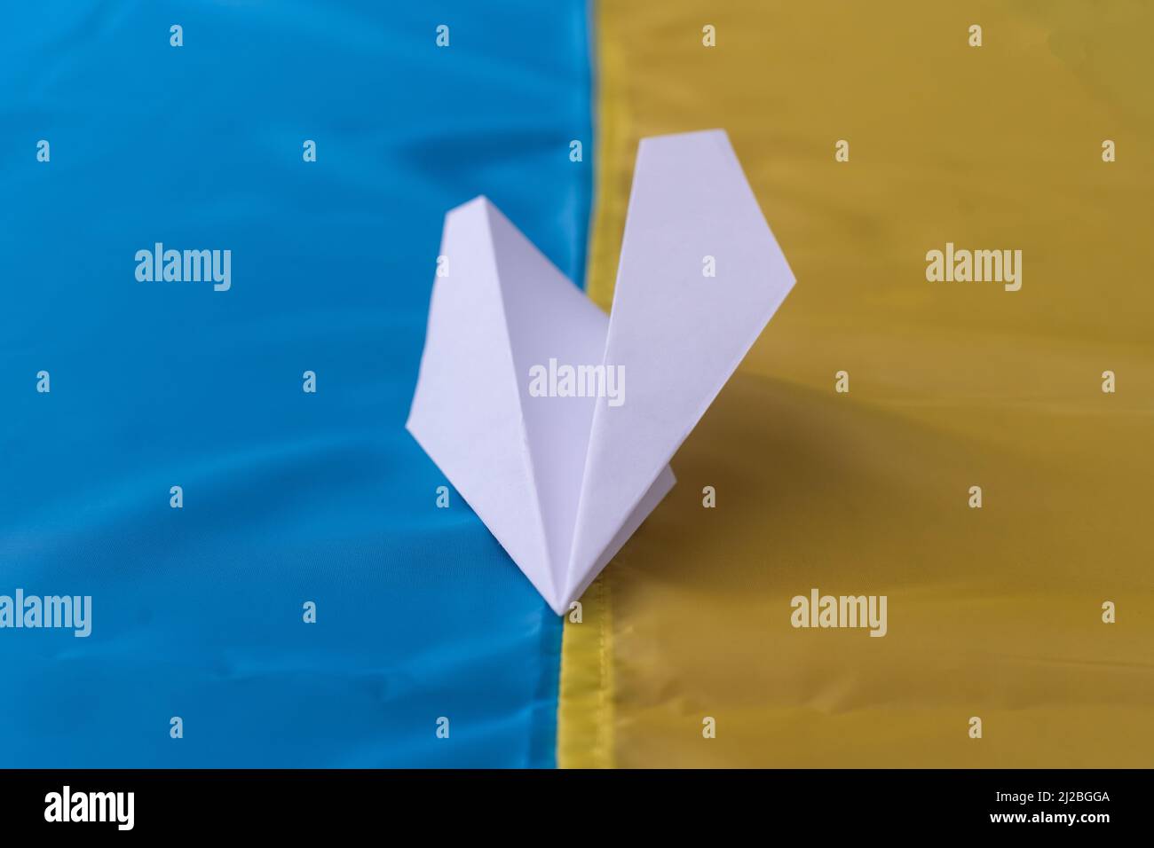 Save Ukraine. paper airplane on the background of the flag of Ukraine ...