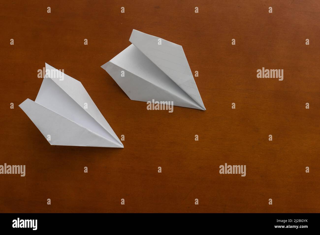 Two Paper Airplanes on a wooden office desk Stock Photo - Alamy