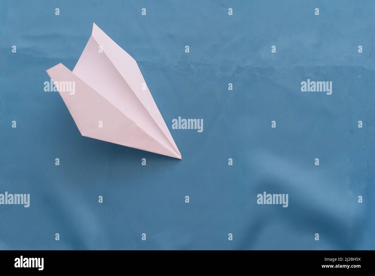 Paper airplane on a blue background Stock Photo - Alamy