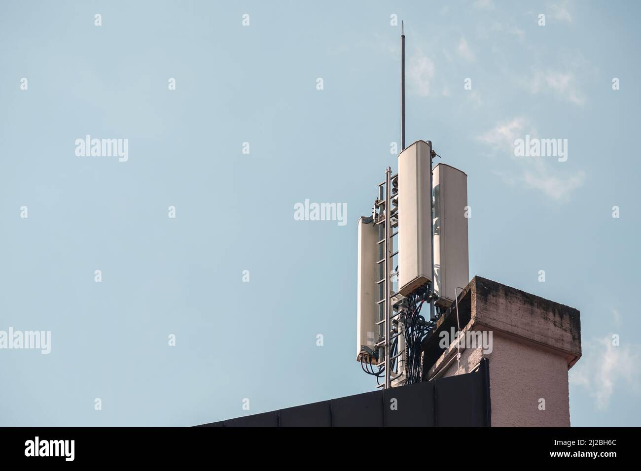 Mobile phone and internet cell tower over against sky. 5G wireless ...