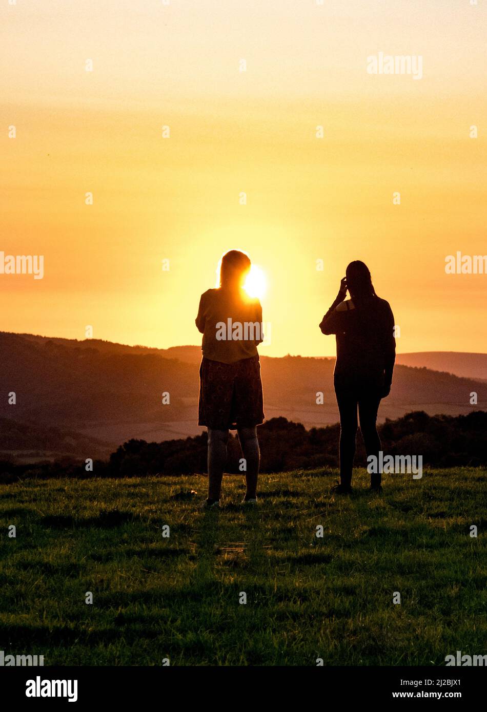 UK, England, Devonshire. A group of people watching the sunset from the ...