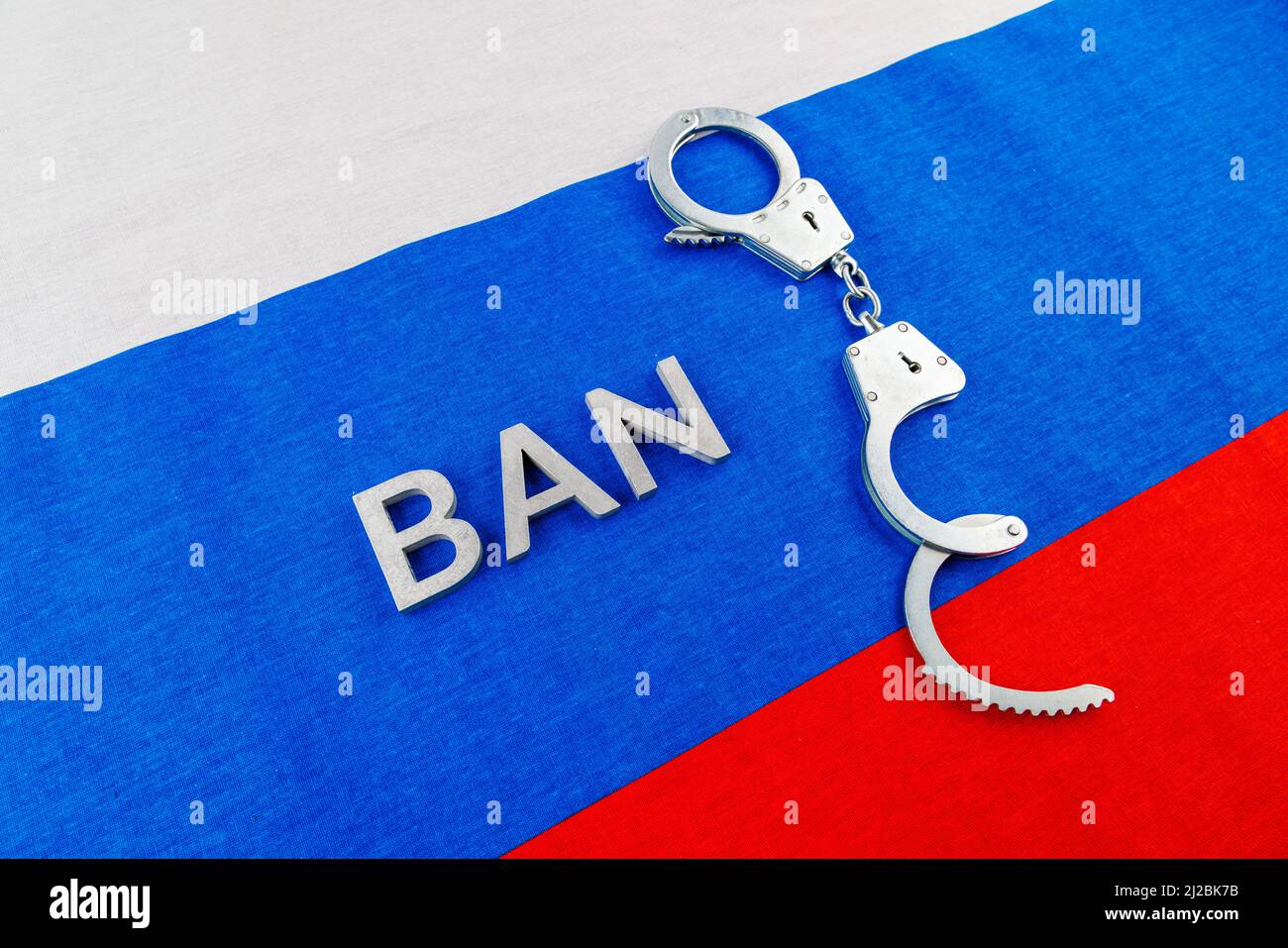 the word ban laid with silver metal letters and handcuffs over fabric ...