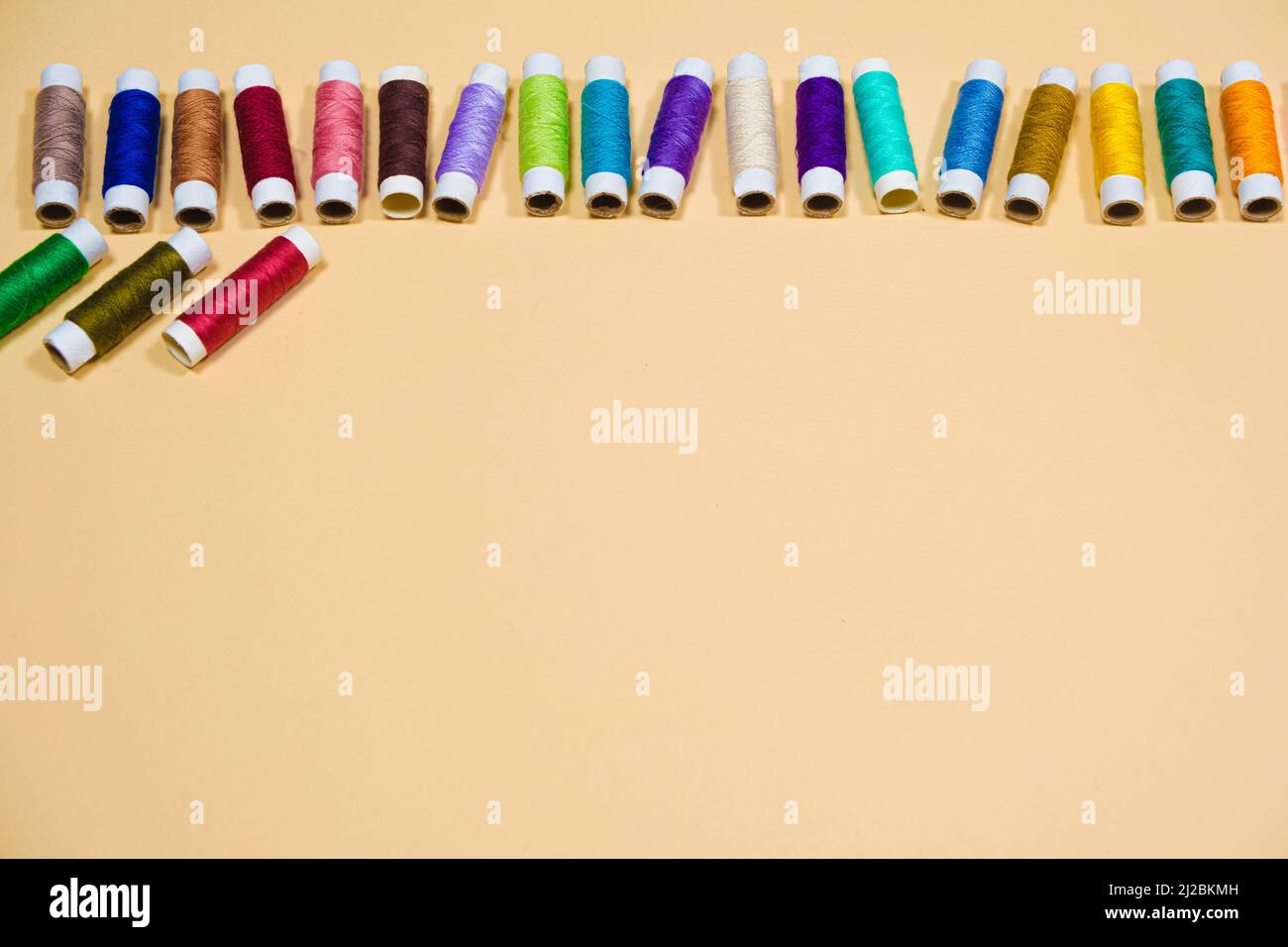 A set of multi-colored threads for sewing with an empty space for text ...