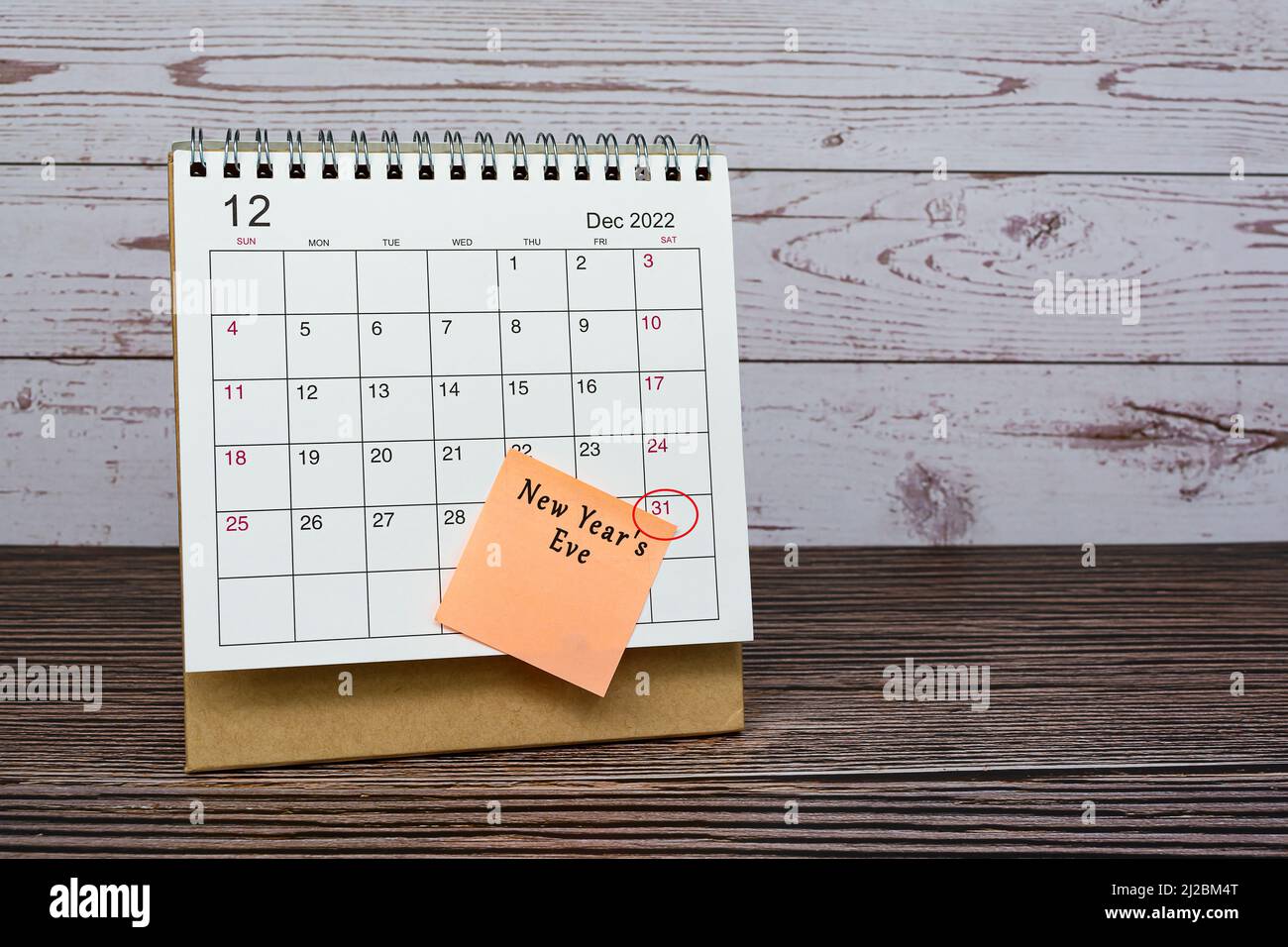 December 2022 calendar on wooden desk with date circle and text on ...