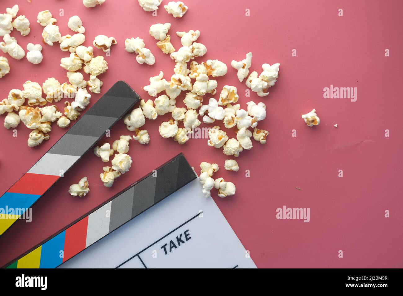 Movie clapper board and popcorn on red background Stock Photo - Alamy