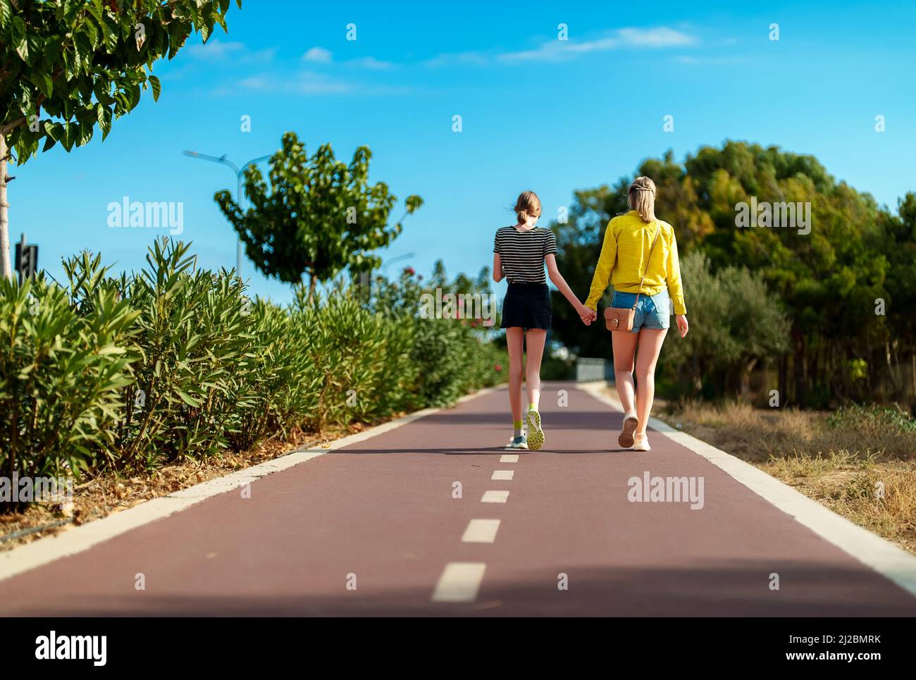 Mom and her daughter walk along the footpath in summer Stock Photo - Alamy