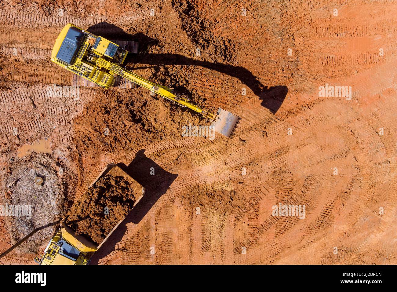 Aerial top down view of an excavator loading earth into a dump truck Stock Photo - Alamy