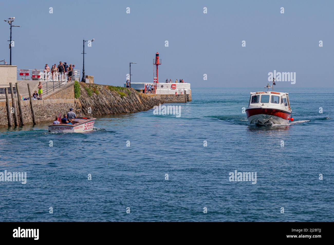 Small boats passing Looe 'Banjo' Pier at the mouth of the East Looe ...