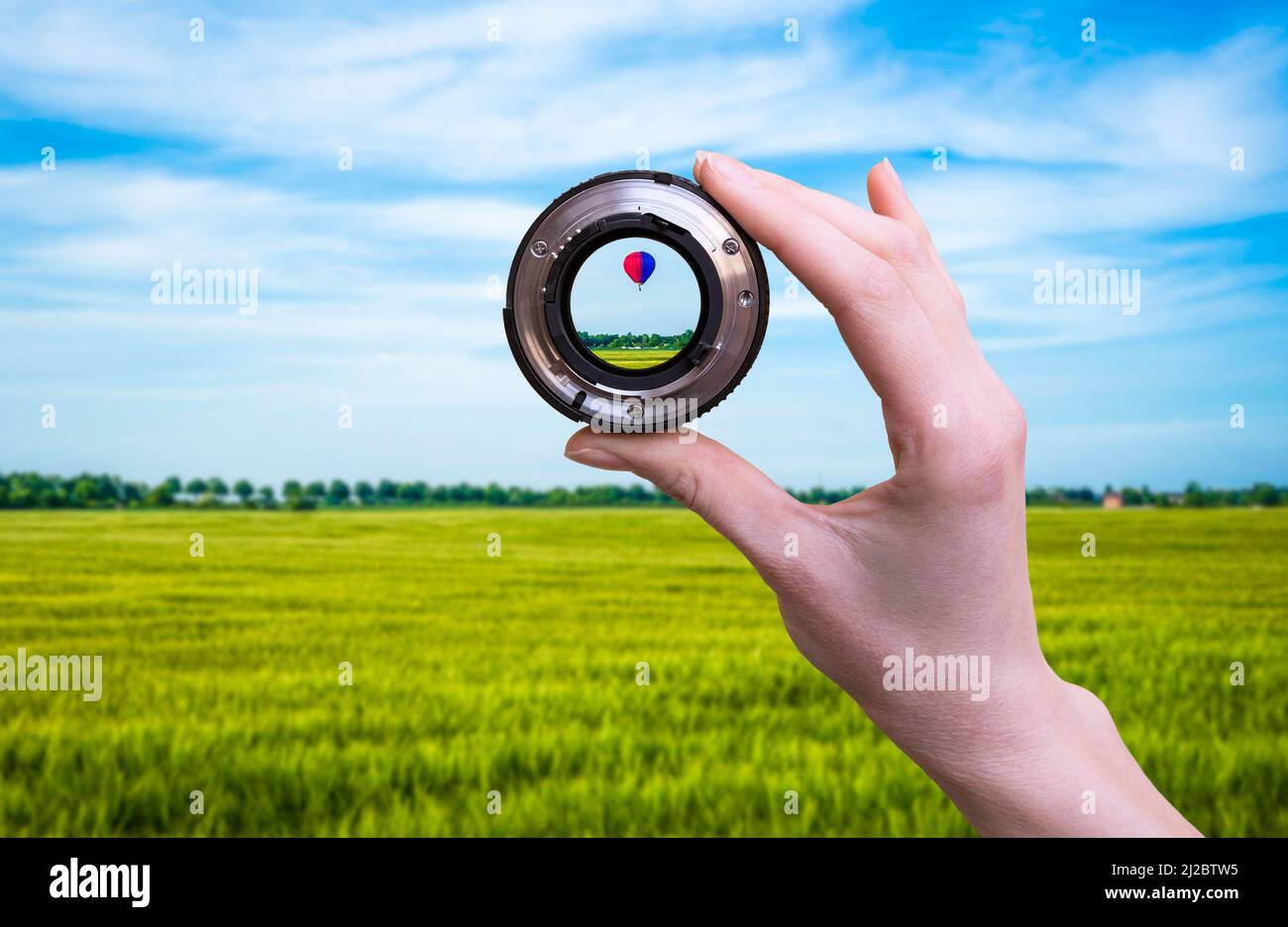 Hand holds optic lens and looking nature Stock Photo - Alamy