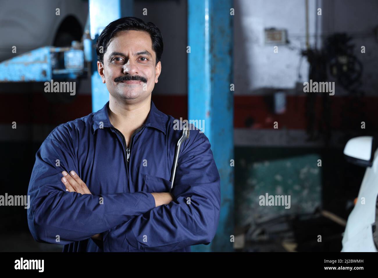 A man with a mustache in a blue shirt is satisfied with his work in ...