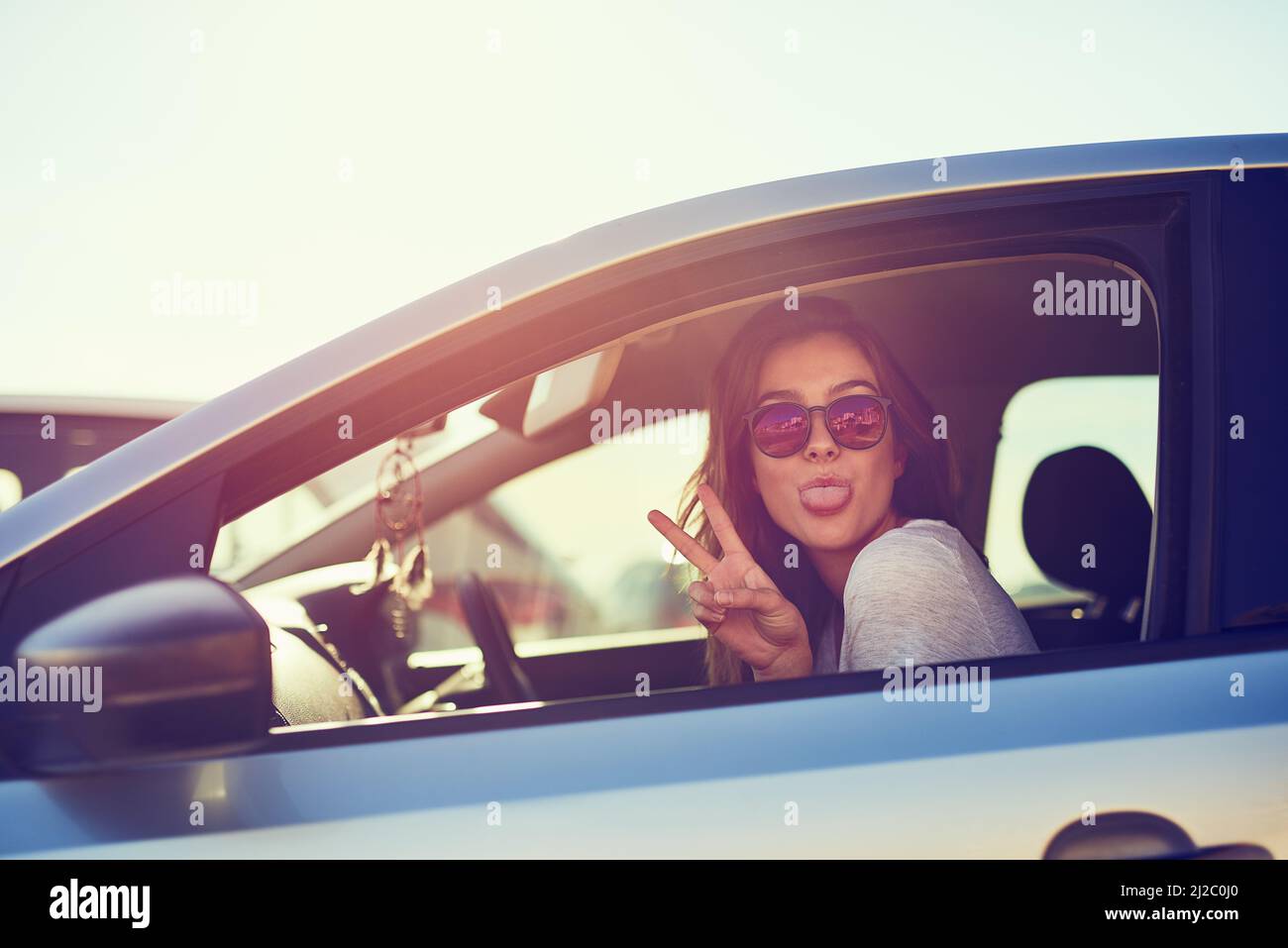 Finding peace on the road. Portrait of a young woman giving you the ...