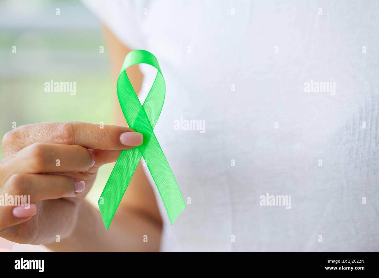 Doctor in uniform holds a green ribbon as a symbol of Lyme disease ...