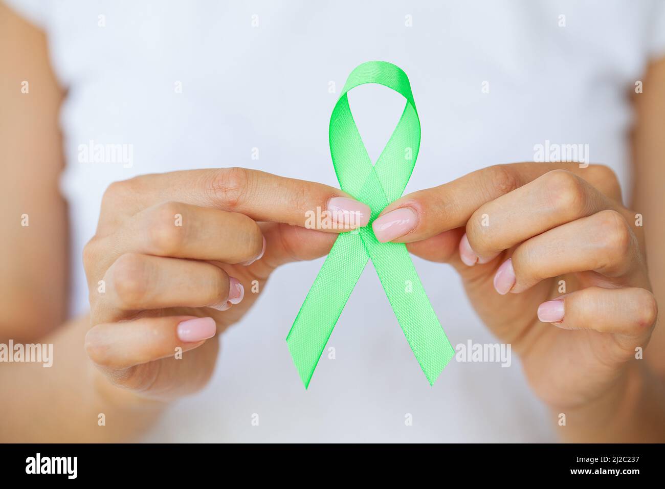 Doctor in uniform holds a green ribbon as a symbol of Lyme disease ...