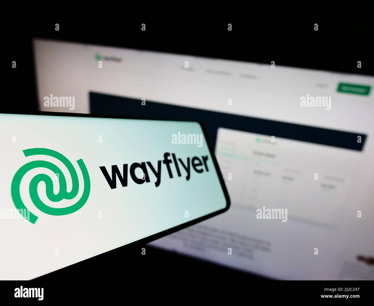 Mobile phone with logo of Irish e-commerce company Wayflyer Limited on screen in front of ...
