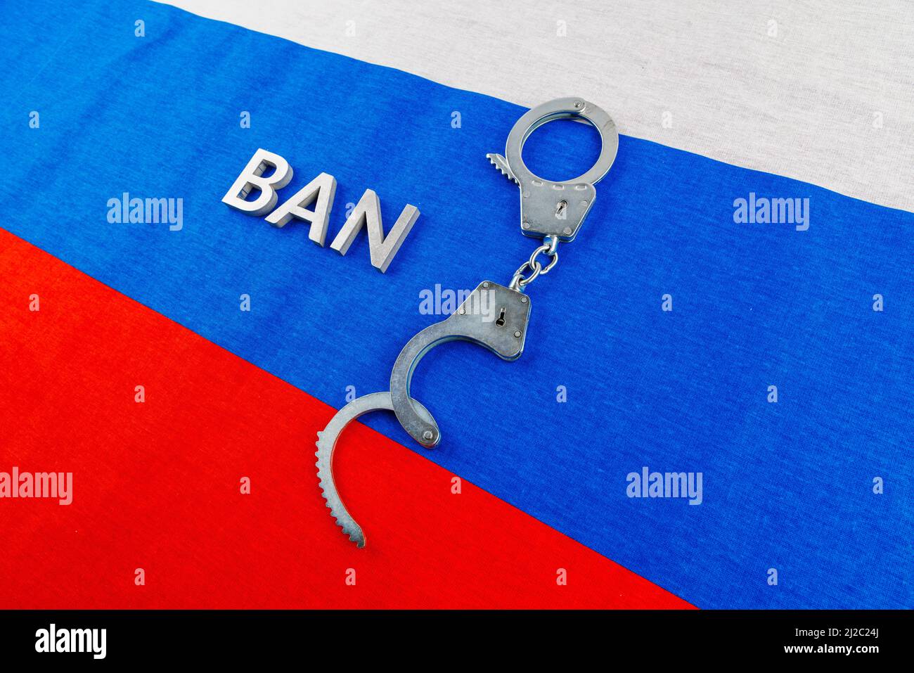 the word ban laid with silver metal letters and handcuffs over fabric ...