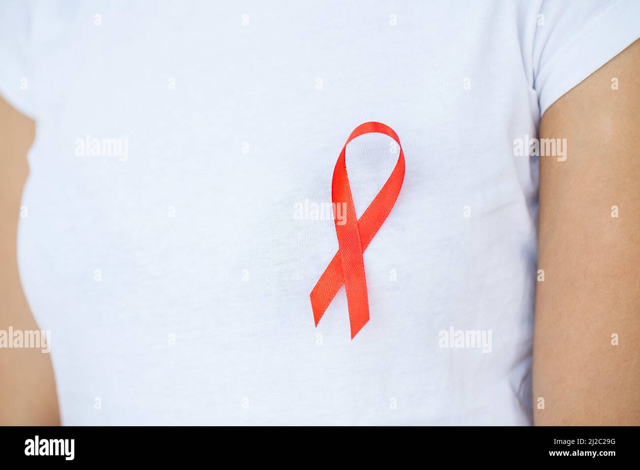 Woman hand holding red ribbon HIV, world AIDS day awareness ribbon Stock Photo - Alamy