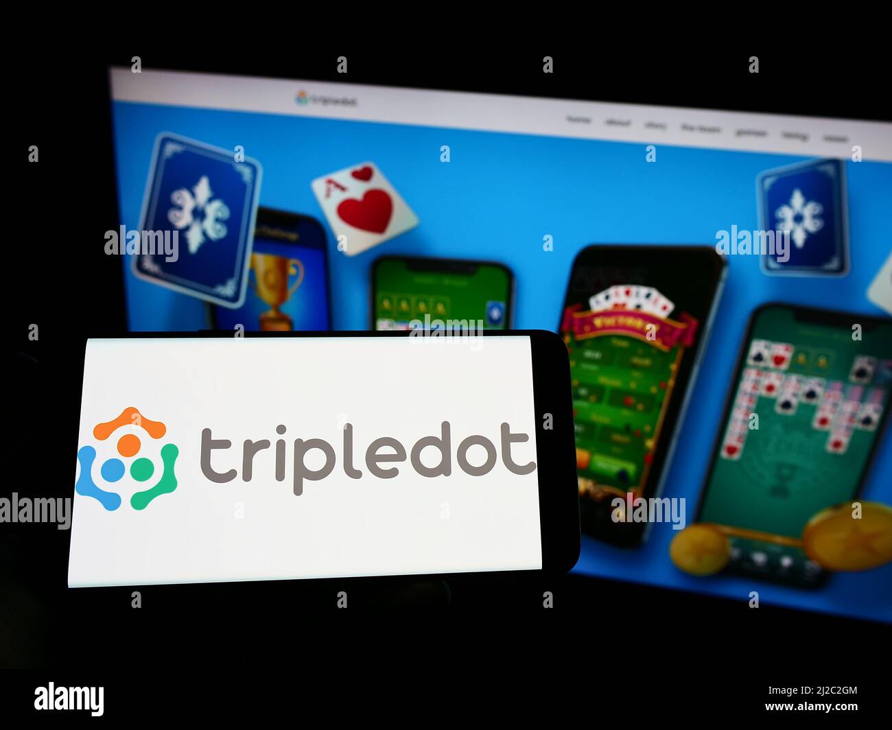 Person holding mobile phone with logo of British gaming company Tripledot Studios Limited on ...