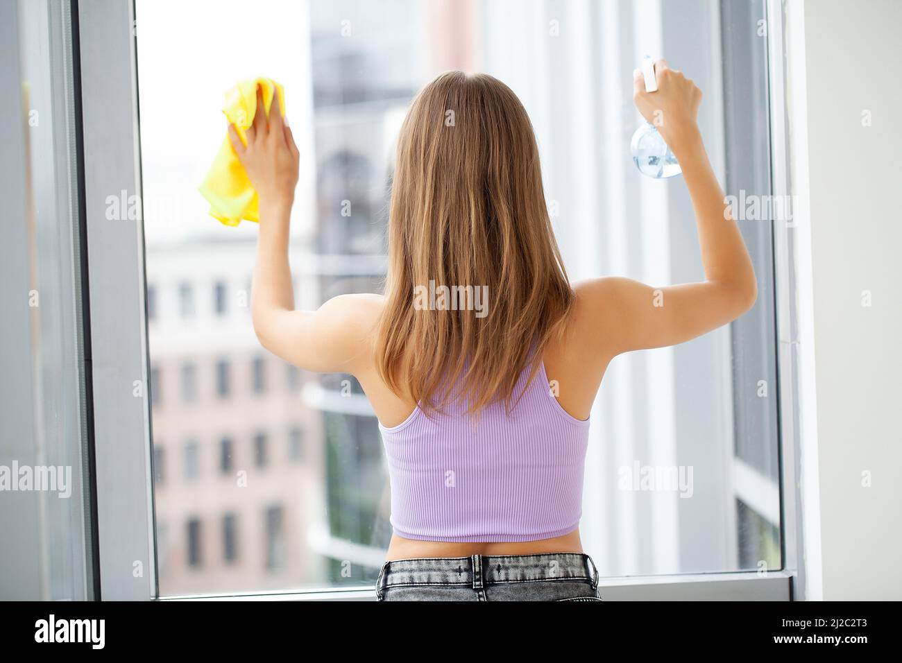 Happy young woman housewife washes a window Stock Photo - Alamy