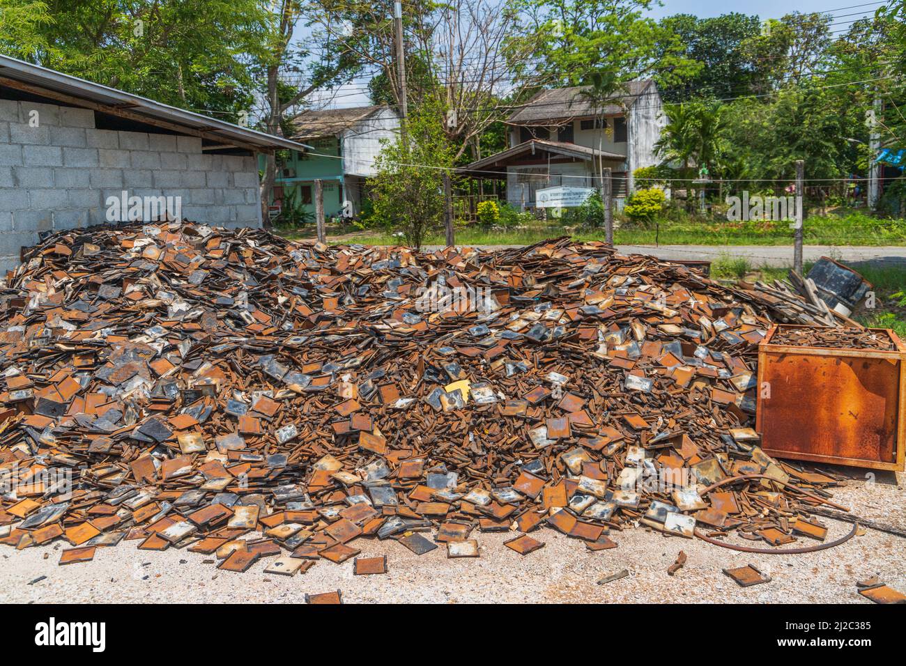 A pile of old, rusty pieces of metal and broken tools in a backyard ...