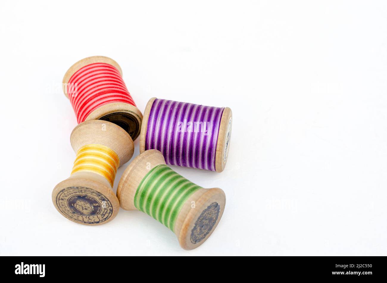 The colorful threads in gradient shades with wooden support on a white ...