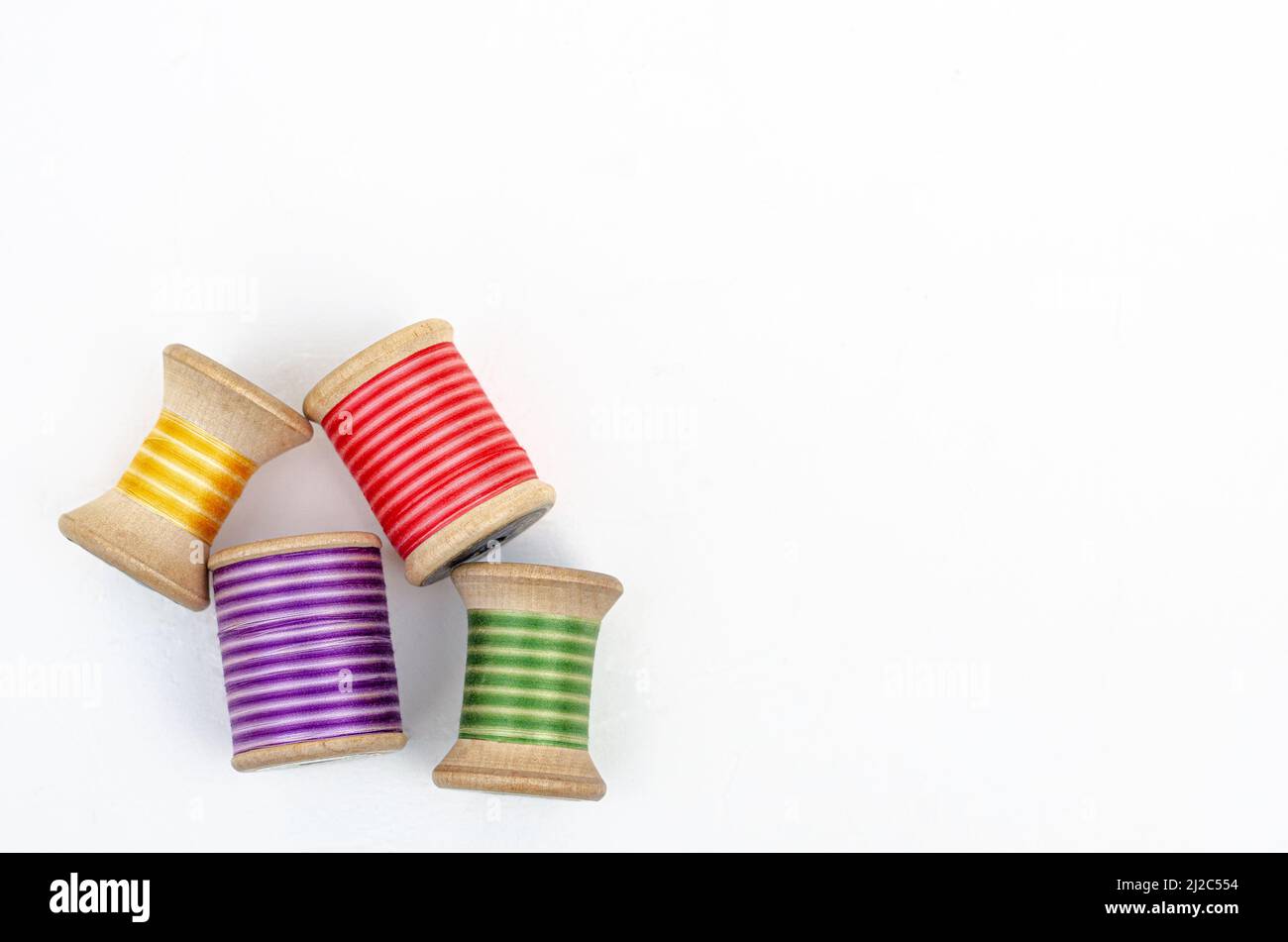 The colorful threads in gradient shades with wooden support on a white ...