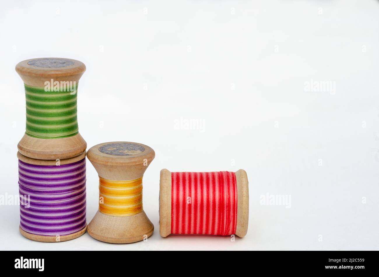 The colorful threads in gradient shades with wooden support on a white ...