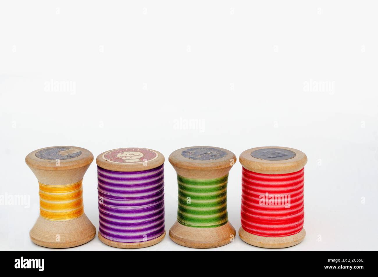 The colorful threads in gradient shades with wooden support on a white ...