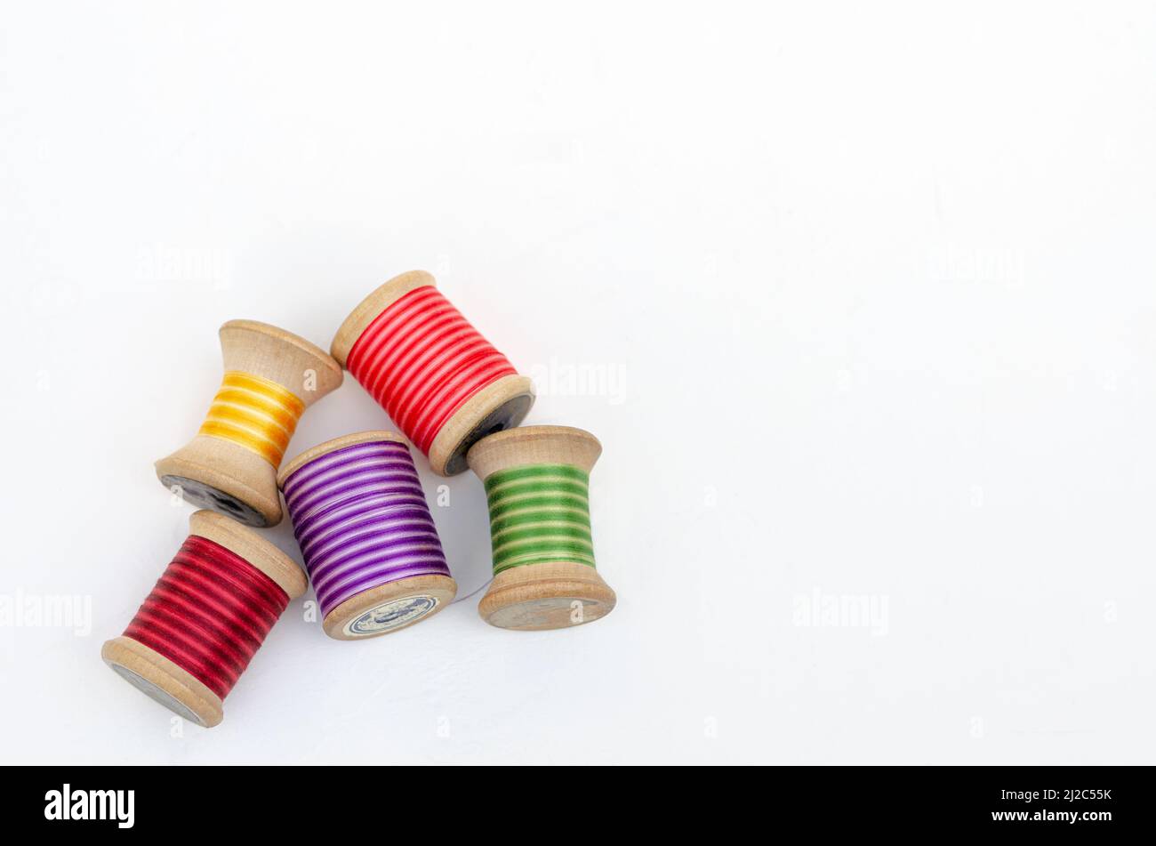 The colorful threads in gradient shades with wooden support on a white ...