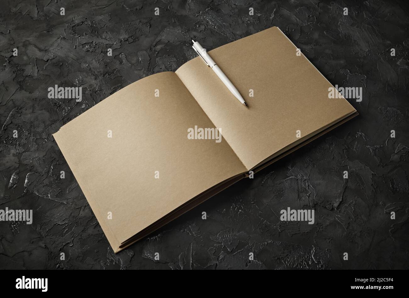 Blank kraft sketchbook and pen mock up on black plaster background ...