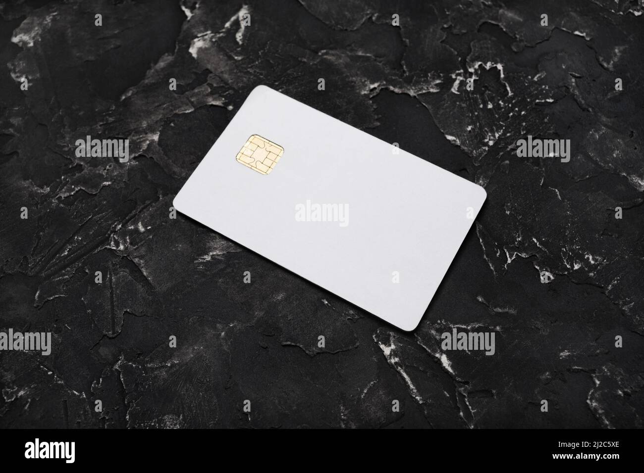 Blank credit card on black plaster background. Photo of white bank card ...
