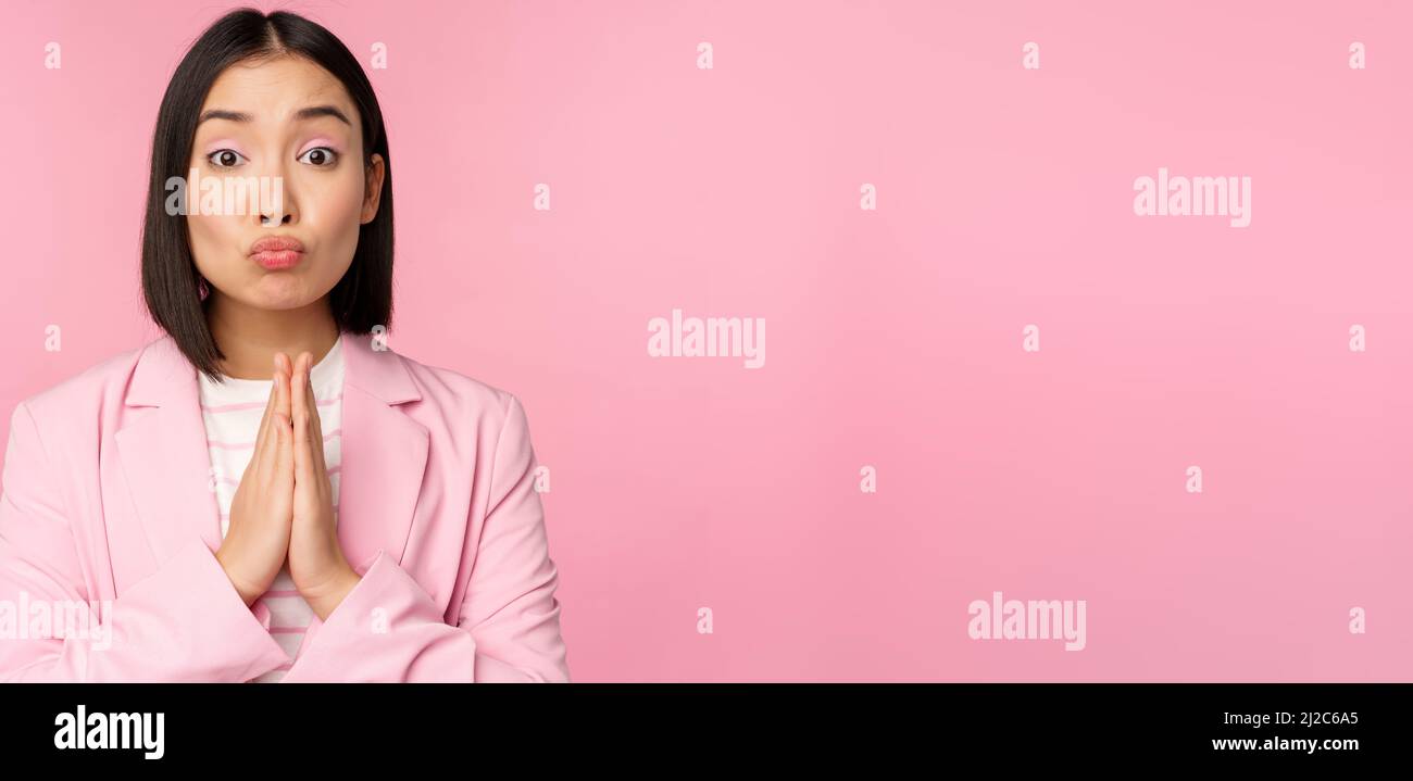 Portrait of asian businesswoman asking for help, say please, standing ...