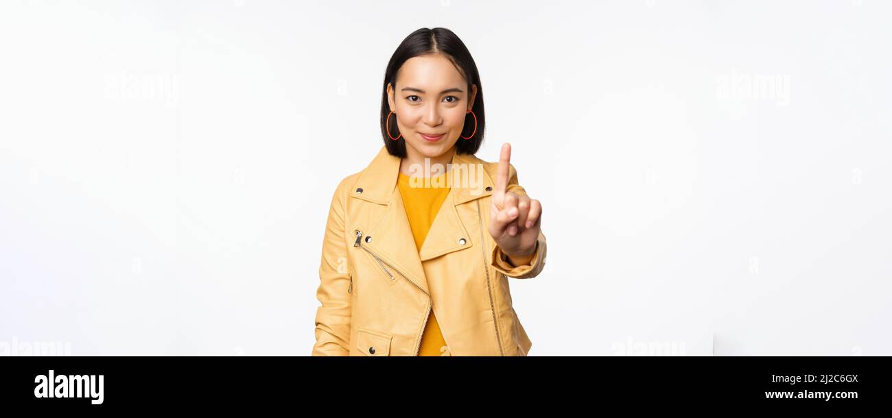 Rule number one. Confident smiling asian woman showing index finger ...