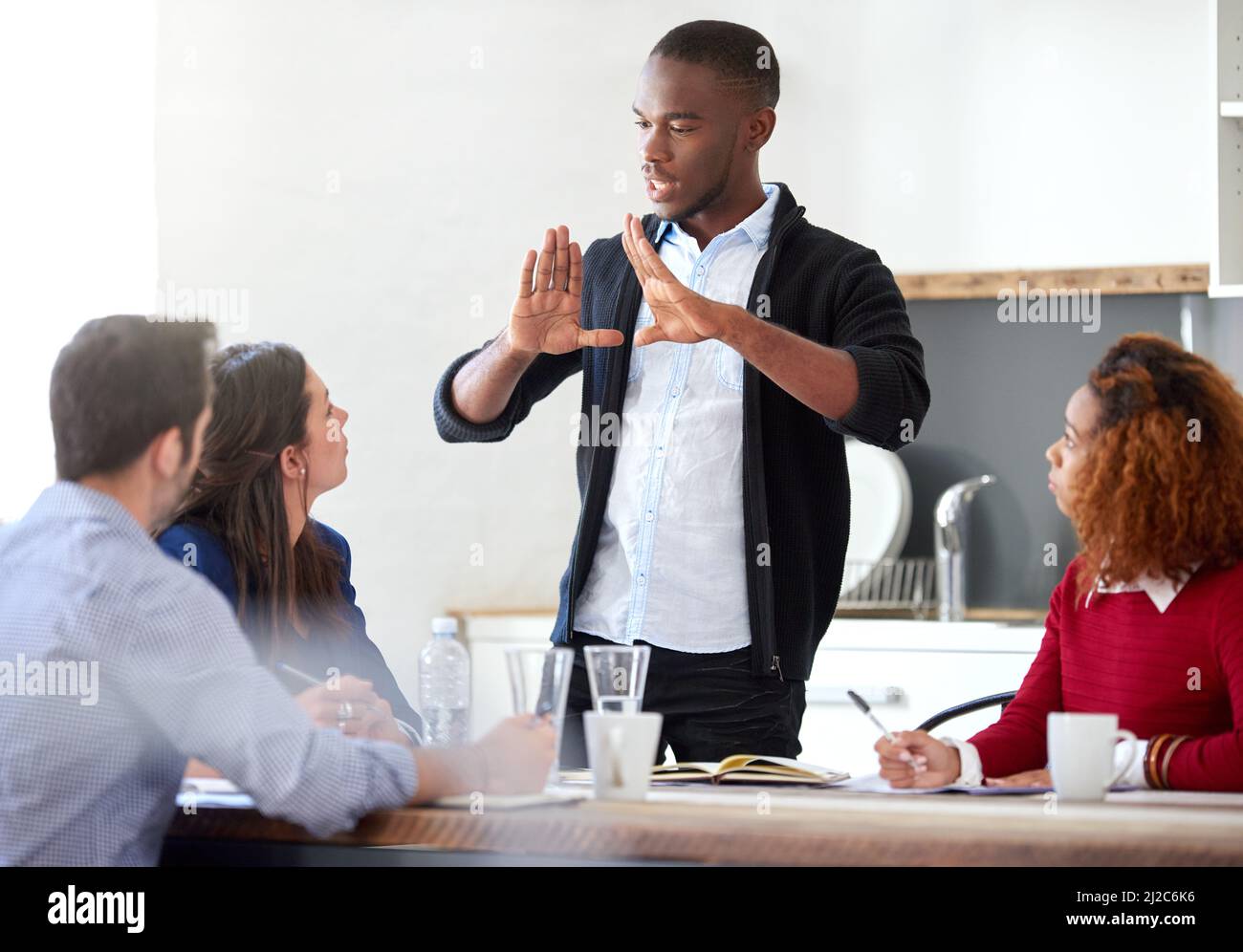 Take a step back.... Cropped shot of a young businessman addressing his ...
