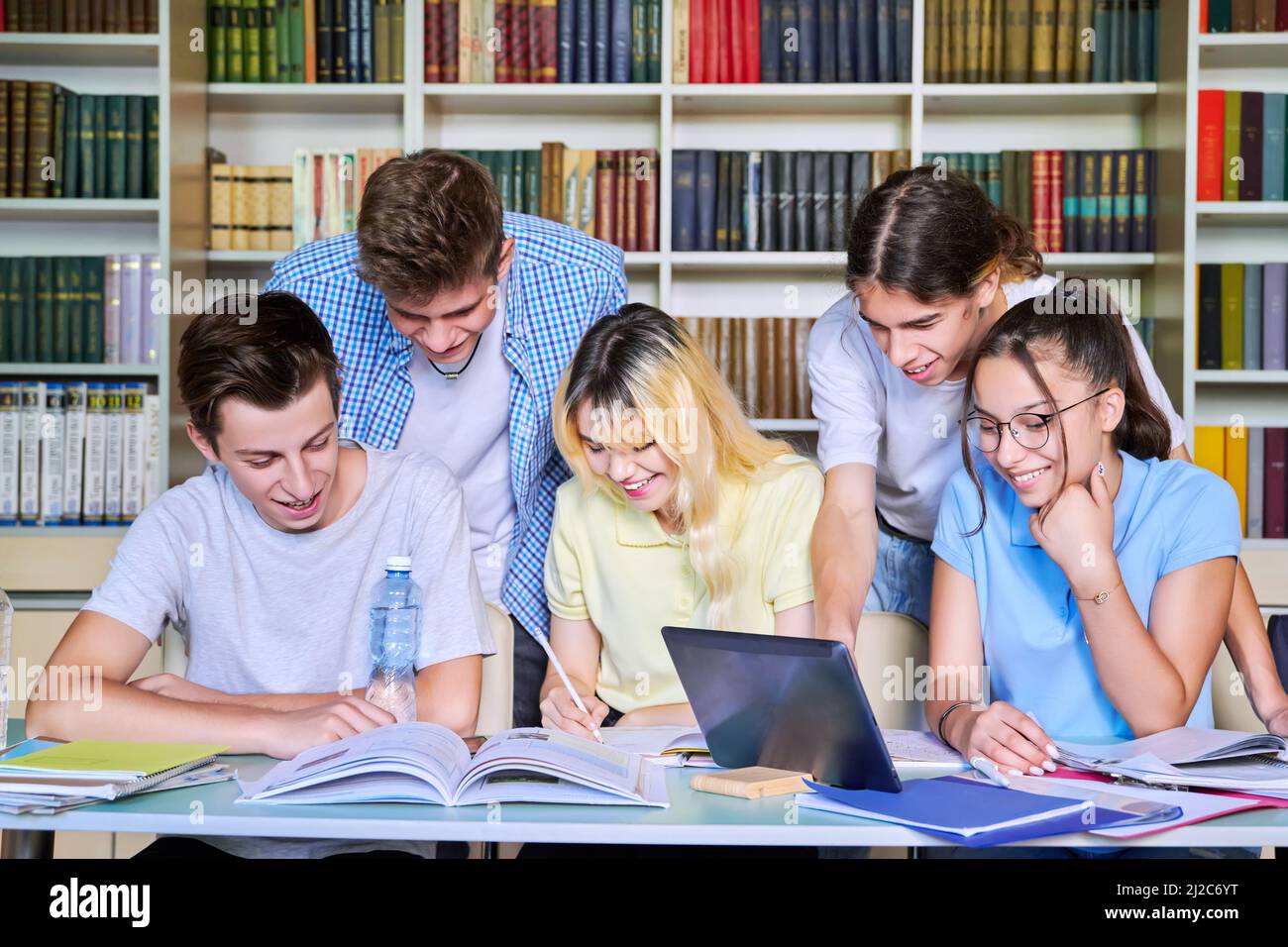 Group of teenage students study in library class Stock Photo - Alamy