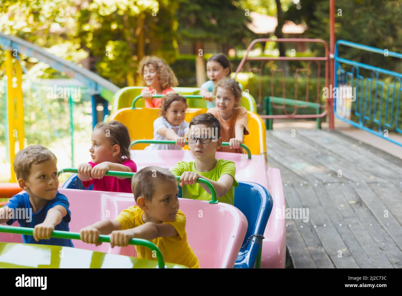 The happy kids on a roller coaster in the amusement park Stock Photo ...
