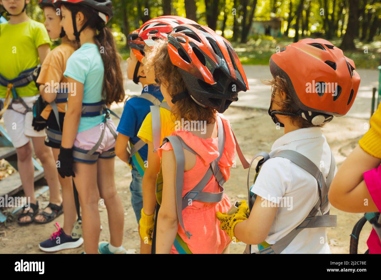 Little boys and girls dressed in protective gear are standing in line ...