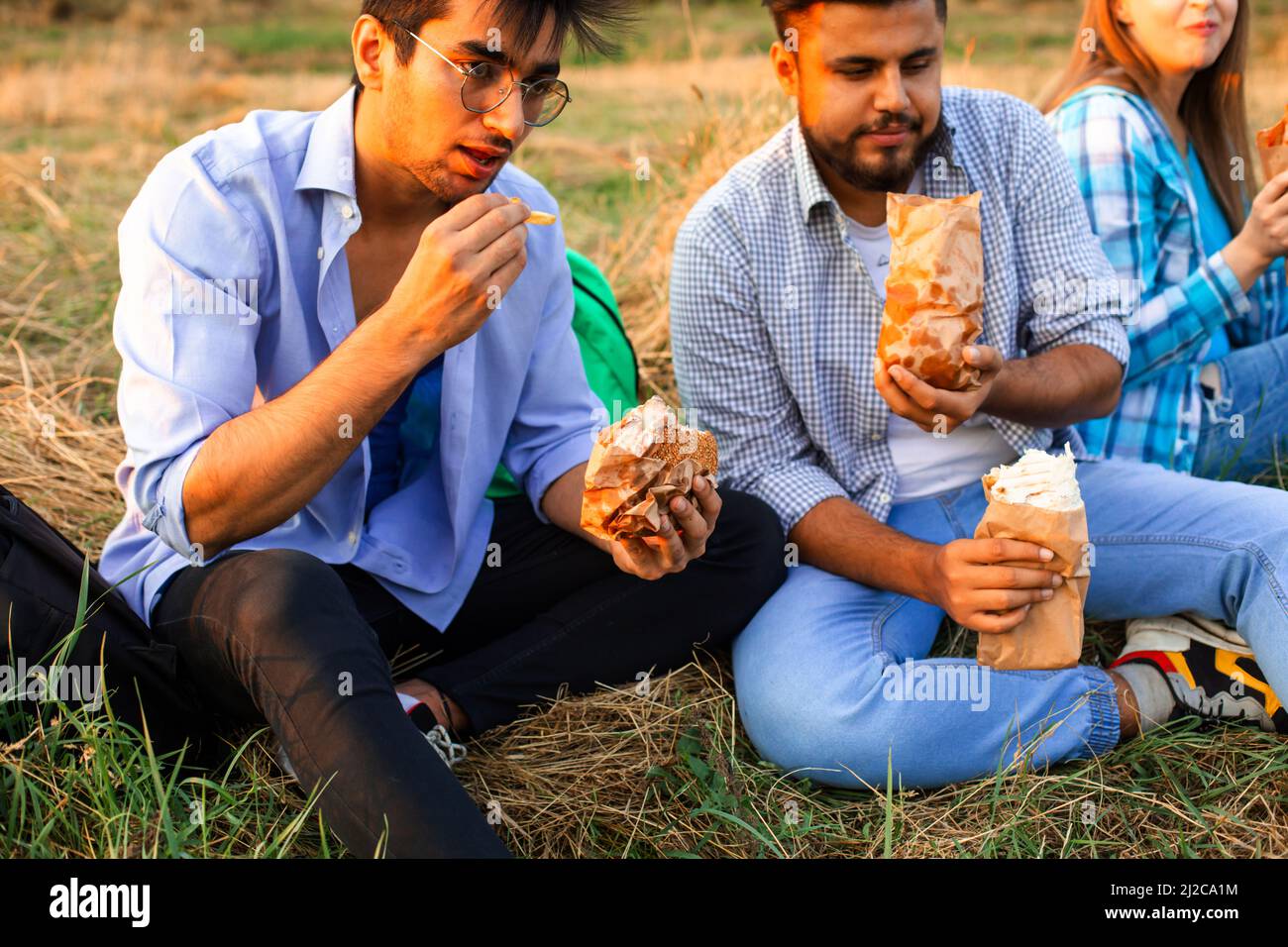 The young multi-ethnic students eating fastfood in campus Stock Photo ...