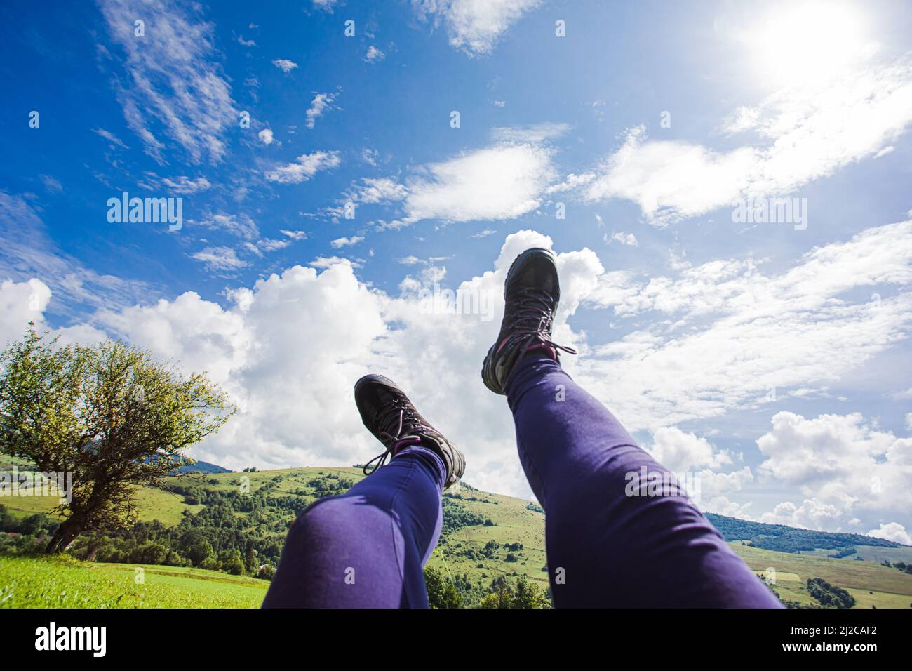 Trekking shoes on the legs over idyllic landscape Stock Photo - Alamy