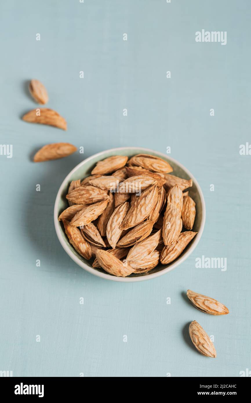 Pile of Almond nuts in a bowl on a light blue background Stock Photo ...