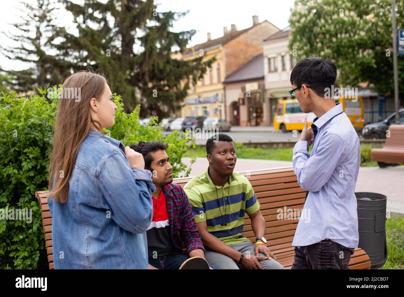 Multiracial group friends on bench hi-res stock photography and images ...