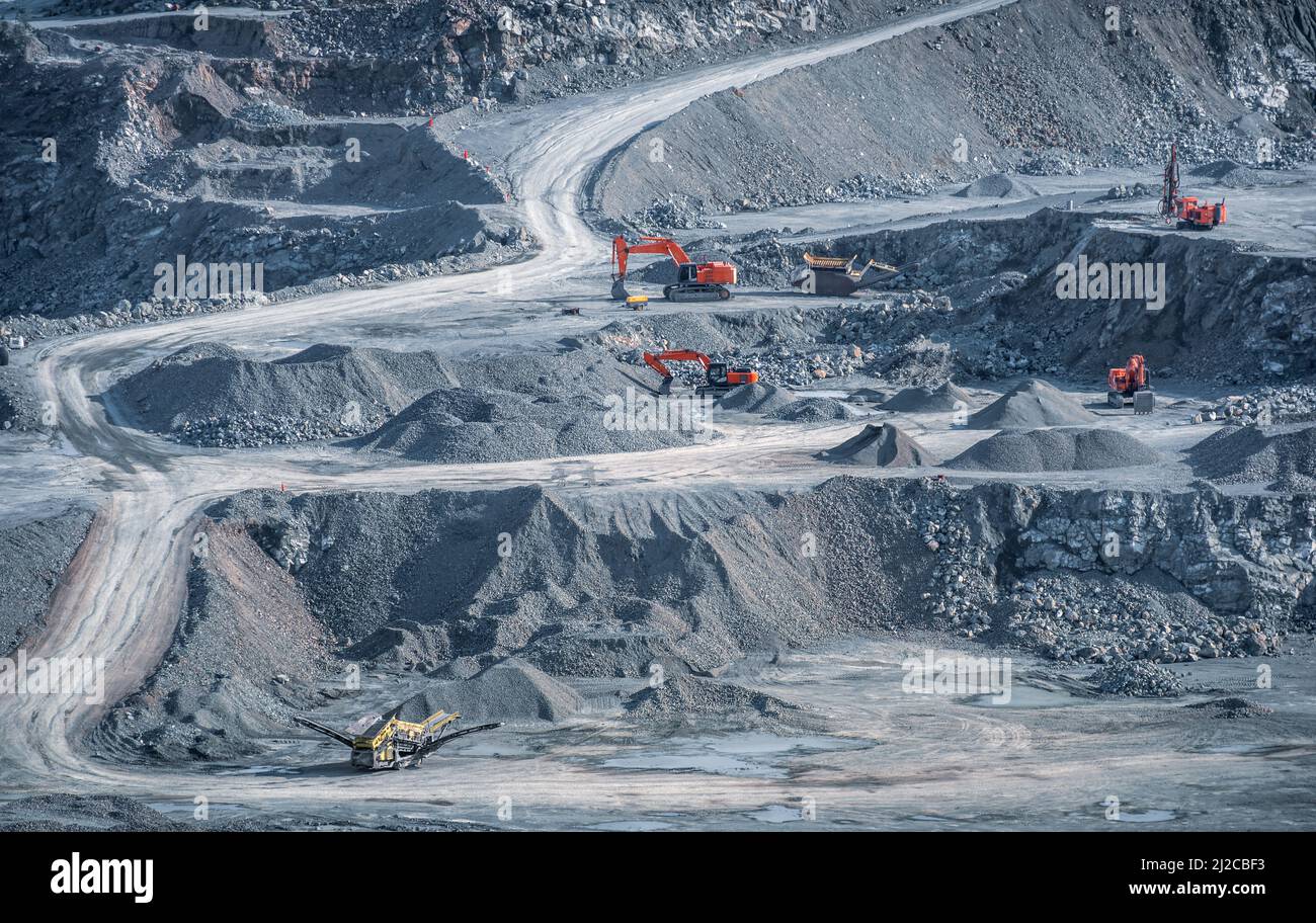 Mining machinery (excavators and drill rigs) work in stone quarry Stock ...