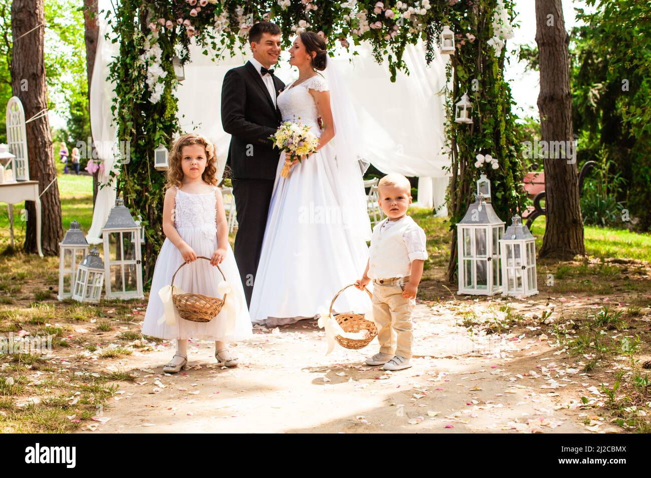 Bride and groom are smiling after wedding ceremony. Adorable children ...
