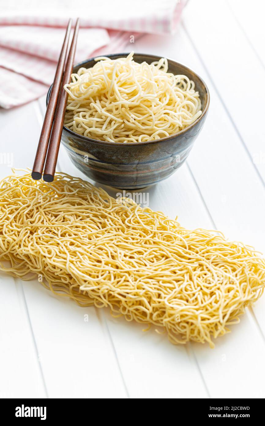 Instant noodles. Cooked and uncooked chinese noodles in a bowl Stock ...