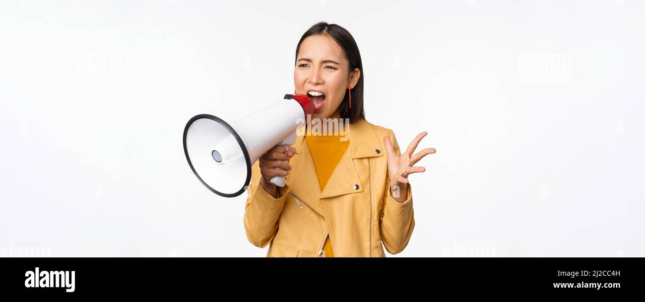 Portrait of young asian woman protester, screaming in megaphone and ...