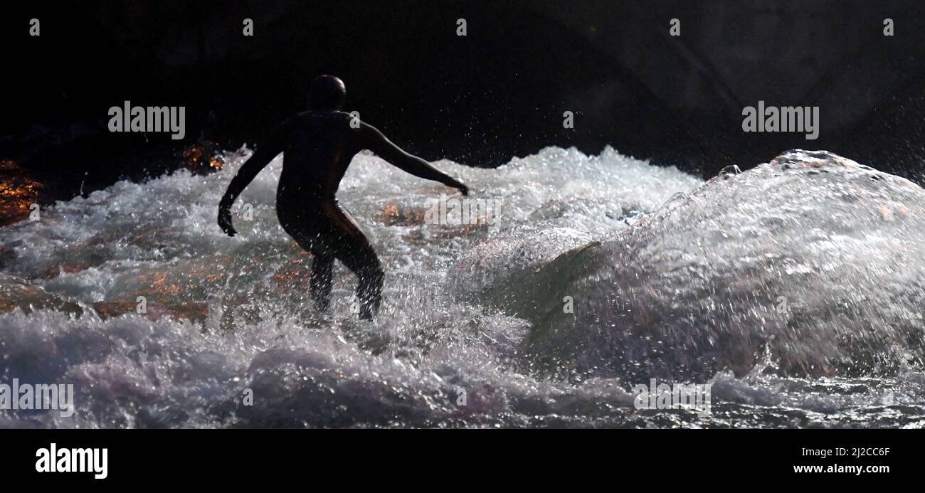Munich, Germany. 31st Mar, 2022. A surfer rides the Eisbach wave in the ...
