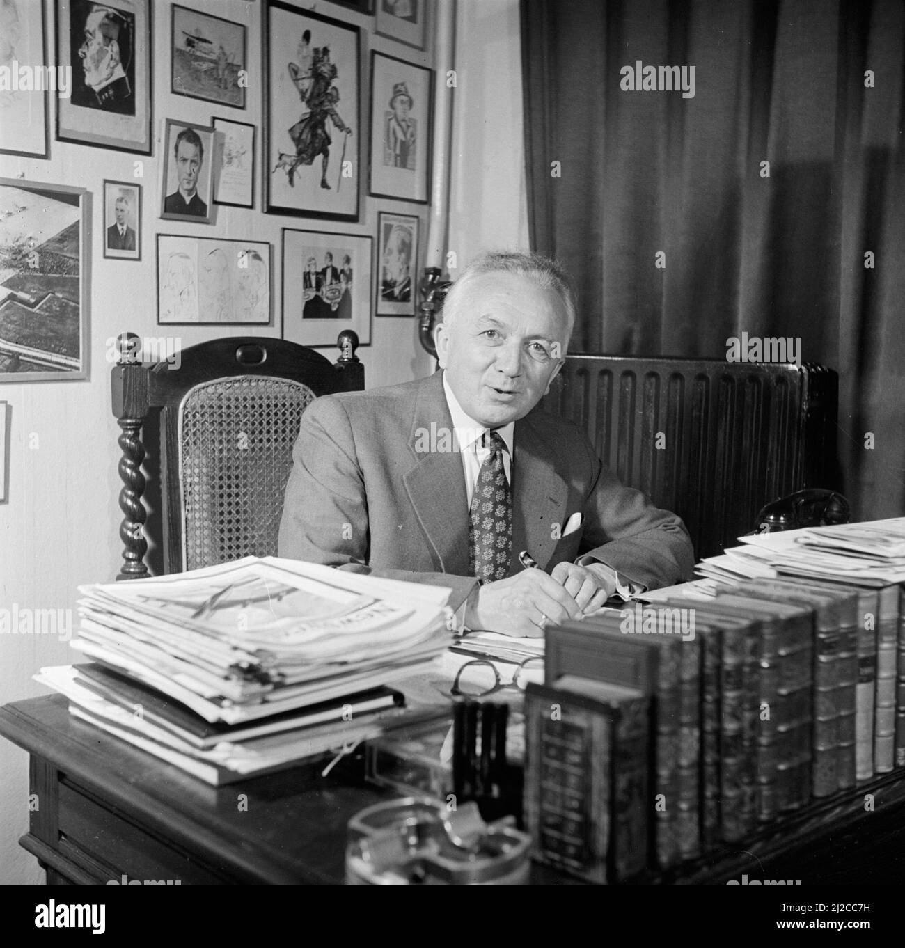 Mr Dellaert at his desk at home. With photos and caricatures in the ...