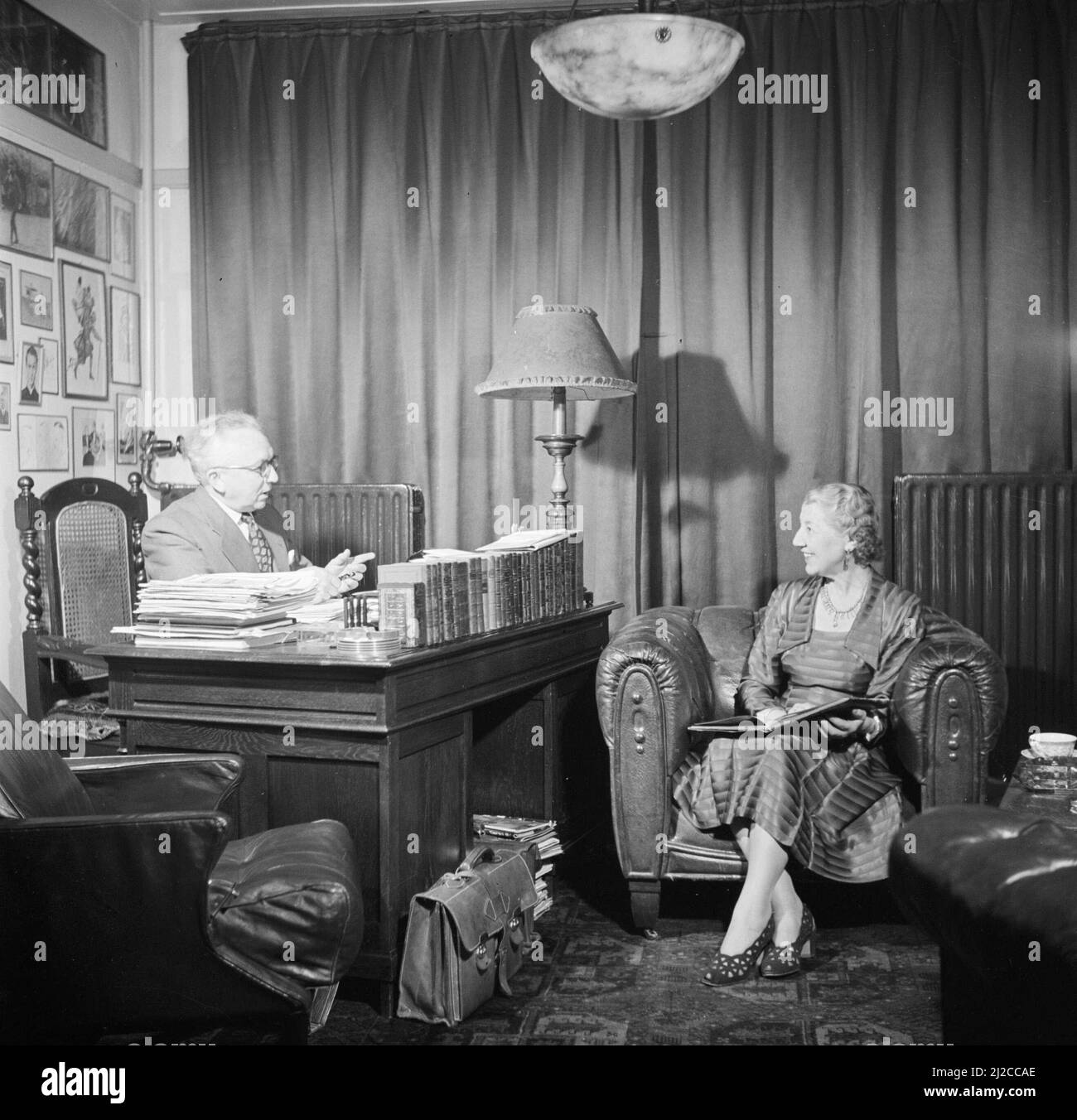 Mr Dellaert at his desk at home. With his wife in an armchair ca: May ...